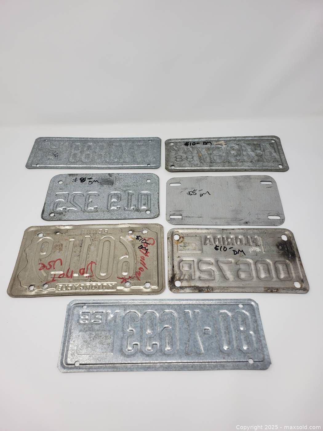 Seven vintage motorcycle license plates | Maxsold