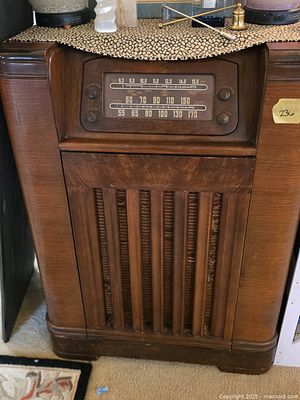 Vintage wood floor console radio with decorative accessories | Maxsold