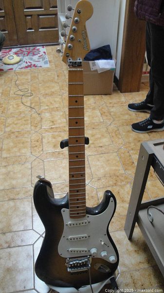 Phoenix Strat-style electric guitar with stand | Maxsold