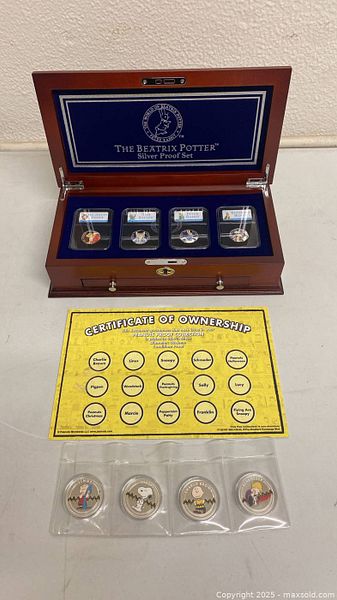 Beatrix Potter silver proof coin set and Peanuts coins | Maxsold